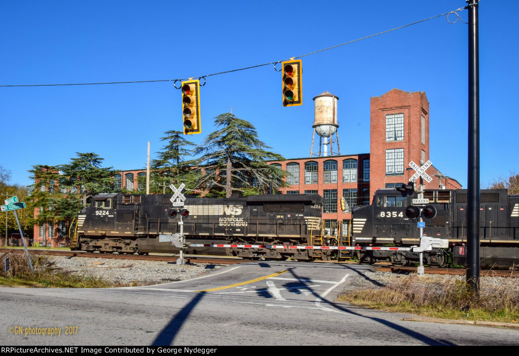 An Intermodal train stopped in front of a former textile mill